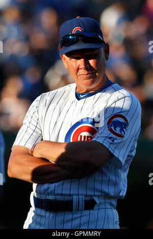 Chicago Cubs coach Mike Quade, holding bat, talks to outfielders, from ...