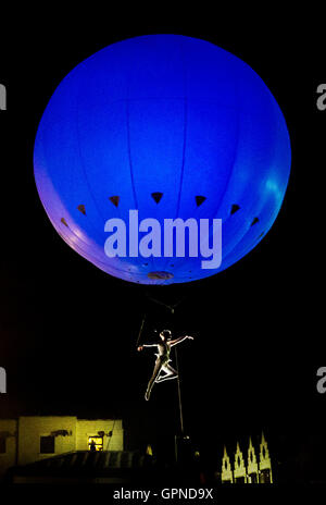 An acrobat is suspended below the Heliosphere, a giant helium balloon ...