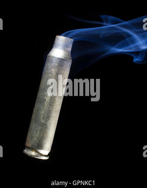 Rifle casing that has smoke coming out on a black background Stock ...