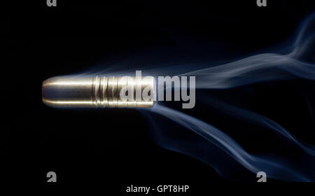 Bullet with a black background and smoke trailing behind Stock Photo ...