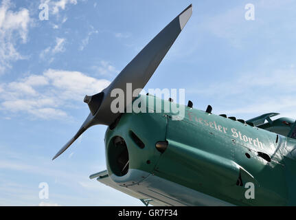 A Fieseler Fi 156 Stork airplane flies over the crowd of people on ...