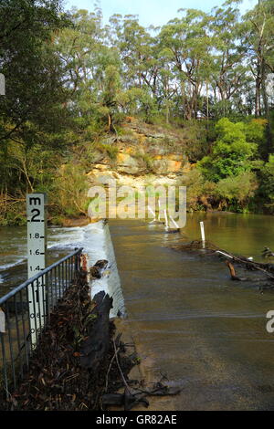 Flooded road crossing over a creek crossing at Belmore Falls near ...