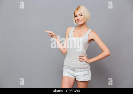 Young blonde woman over isolated background covering one eye with hand ...