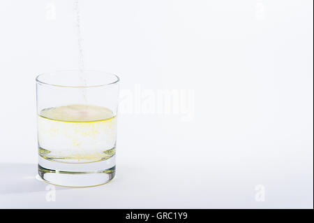 Yellow Powder Is Poured Into The Water Glass Stock Photo - Alamy