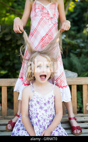 a cheeky girl pulling a funny face with angel on the top Stock Photo ...