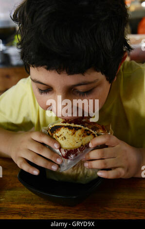 A boy eating Arepa con Carne ( Arepa with meat Stock Photo - Alamy