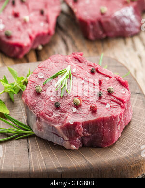 Raw beef on wooden cutting board with garlic and bazil Stock Photo - Alamy