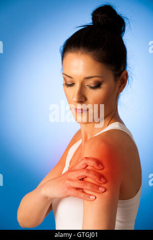 Young hispanic woman touching injury arm at clinic Stock Photo - Alamy