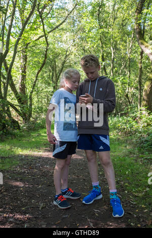 Two children playing Pokemon Go in the countryside Stock Photo - Alamy