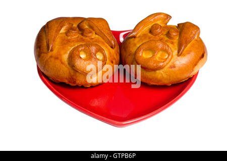 Two pigs of bread in a red heart-shaped plate Stock Photo - Alamy