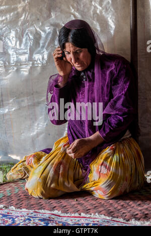 Khoram Gol, nomadic Basseri woman on her cell phone. The Basseri are a ...