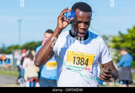 Man cooling off with water while running in a race Stock Photo - Alamy