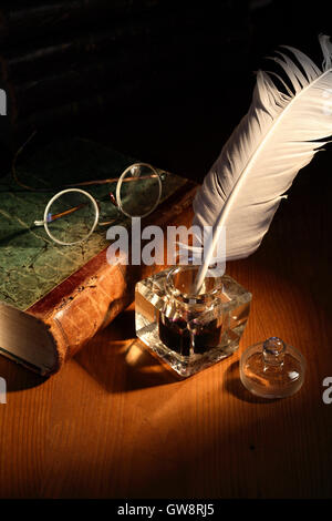 Vintage set with quill and ink pot on top of parchment paper inside ...