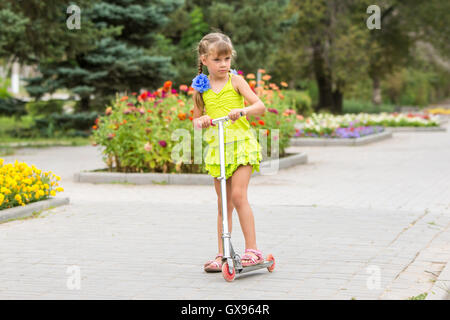 A girl riding a scooter down an alley with the one way sign and arrow ...