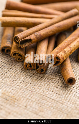 Aromatic cinnamon sticks on burlap fabric, closeup Stock Photo - Alamy