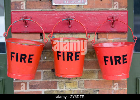 Red fire buckets filled with sand Stock Photo - Alamy