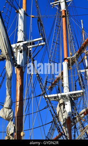 Sailing ship mast detail with sail furled on yardarm, mast top, shrouds ...