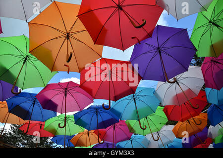 Opened colorful umbrellas with parts of spring blue sky with clouds ...