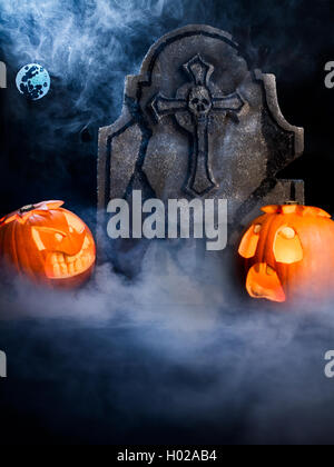 Angry face and scared face of Halloween pumpkins with tombstone on ...