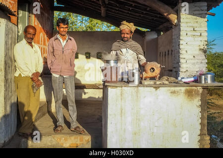 A vendor prepares traditional tea for his customers at a his tea stall ...
