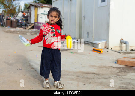 Portrait of a poor little romani gypsy boy on the street in the ghetto ...
