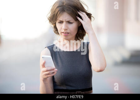 Woman looking at cellphone in the street Stock Photo - Alamy