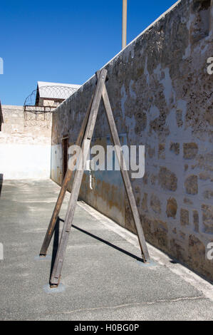 Old wooden whipping post with a limestone brick wall at the Fremantle ...