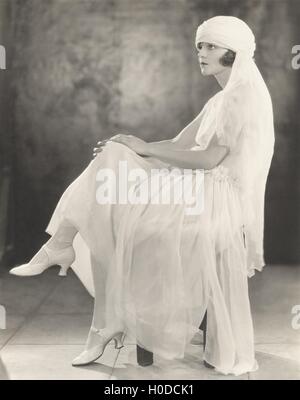 Woman in black dress and white sneakers sitting and resting, high angle ...
