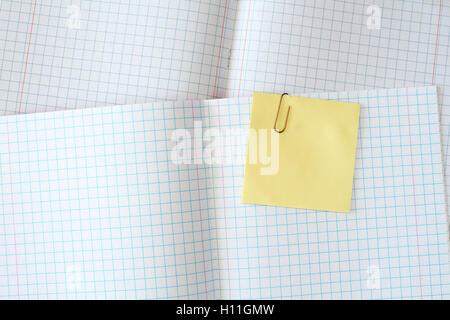 Squared exercise book with sticky note Stock Photo - Alamy
