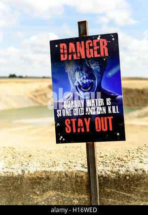 Sign warning of deep cold water in a flooded pit at Clee Hill Quarry in ...