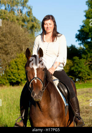 Woman horseback riding on beautiful white horse outdoors in nature and ...