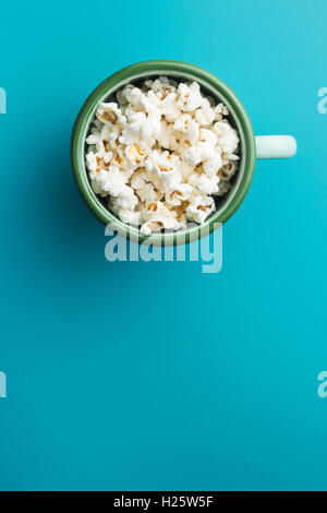 top view of delicious popcorn in frying pan near corn on wooden ...
