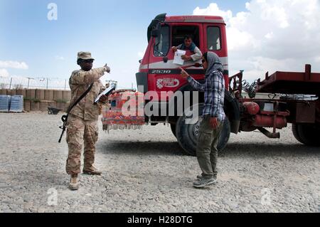 Drivers of a U.S. Army truck convoy stops to have a smoke on the desert ...