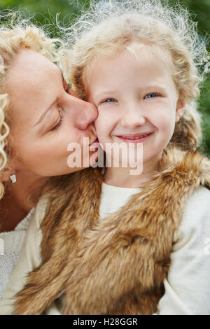 Mother with her daughter kissing outside in winter nature Stock Photo - Alamy