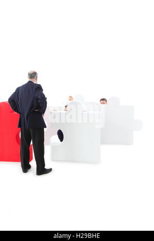 Business people hiding behind puzzle pices Stock Photo - Alamy