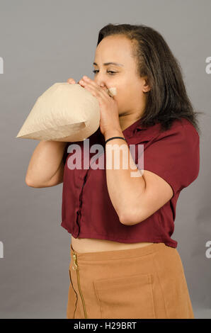 Adult woman blowing up and bursting a paper bag Stock Photo - Alamy