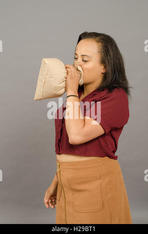 Adult woman blowing up and bursting a paper bag Stock Photo - Alamy