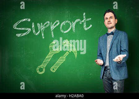 Support employee in a jacket by a chalkboard Stock Photo - Alamy