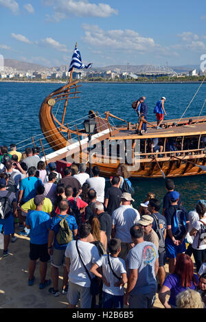 Volunteer rowers getting on board a full scale copy of an ancient ...