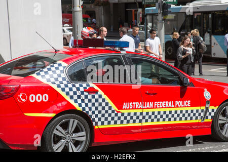 Australian Federal police AFP officers in a marked red police car in ...