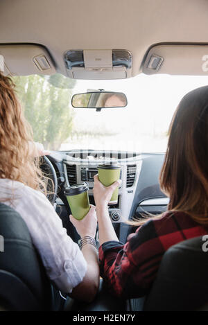 Two women with cups of coffee on bright background Stock Photo - Alamy