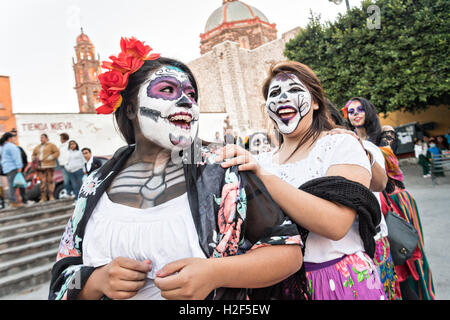 Young women, dressed as La Catrina, take part in the Day of the Dead ...