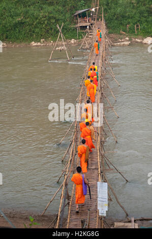 Monks crossing a bamboo bridge over the Nam Khan river in Luang Prabang ...