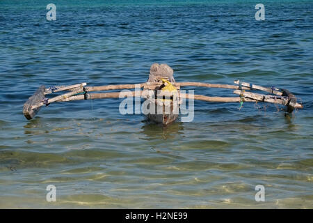 A Ngalawa or Ungalawa traditional, double-outrigger canoe used as a ...