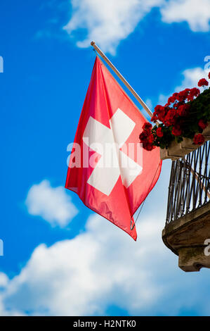 A Swiss national flag hangs from the window of a residential building ...