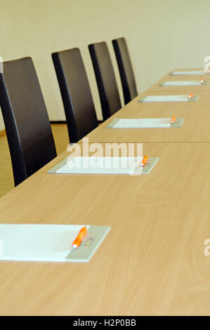 Table with notebook prepared for business meeting in conference hall ...