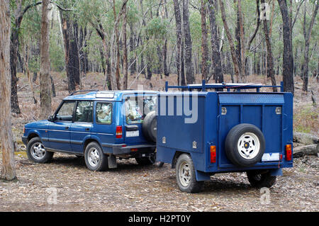 All terrain vehicle with a large trailer in a forest road in the ...