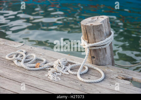 Coiled rope on teak deck. Decorative coiling is called 'cheesing' or ...