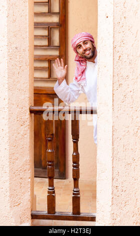 Young arab man with beard wearing casual striped sweater making fish ...