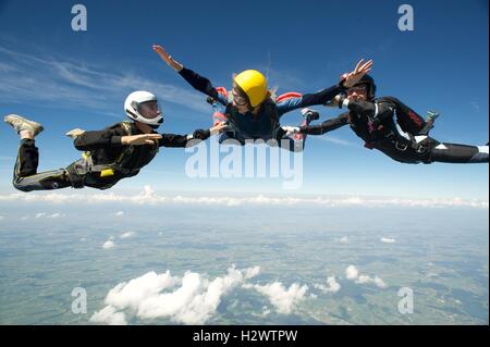 Woman on her first freefall jump with two instructors Stock Photo - Alamy